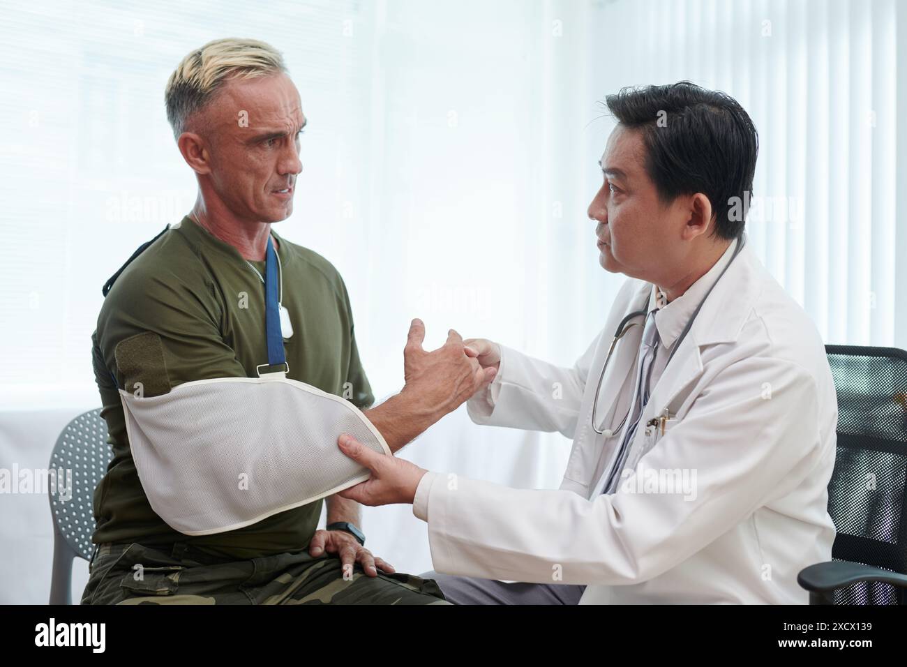 Doctor Putting Bandage On Arm Of Soldier Stock Photo - Alamy