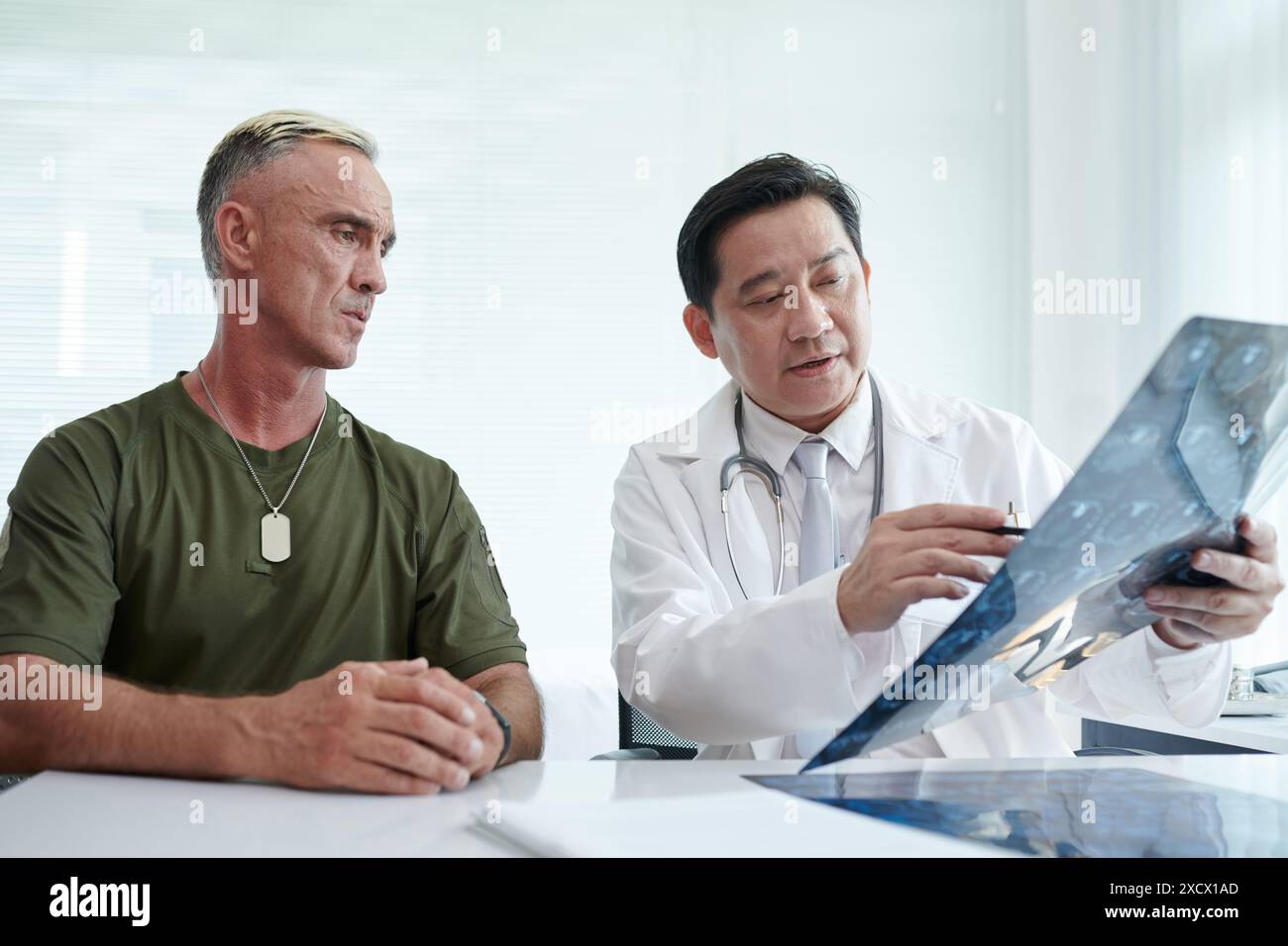 Doctor Examining X-ray Image With Soldier Stock Photo - Alamy