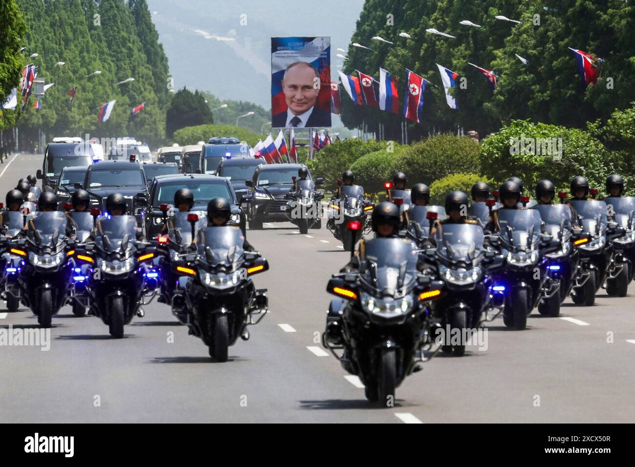A motorcade with Russian President Vladimir Putin drives along a street ...