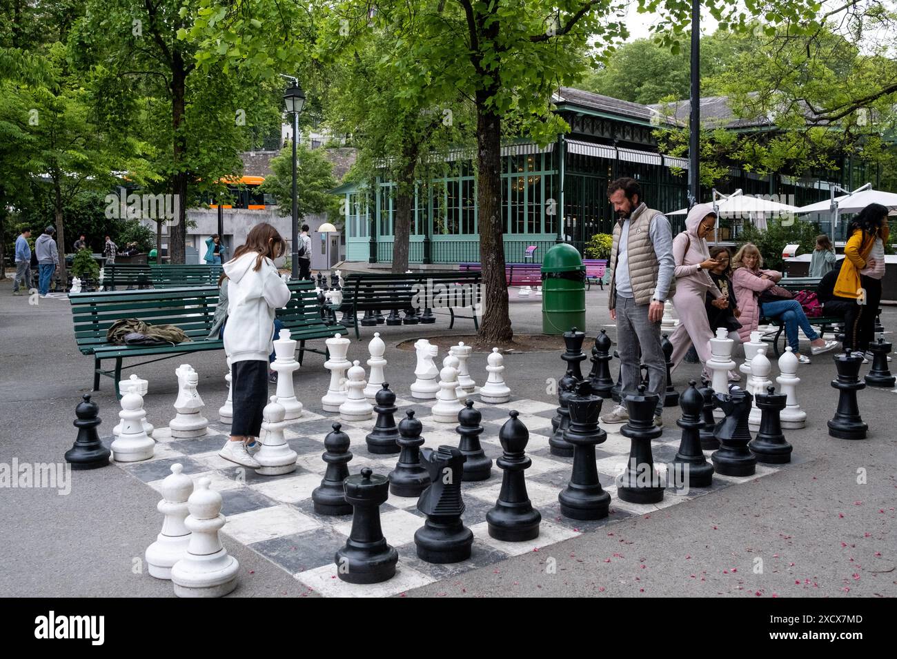 Family and child playing a game of giant chess in the Park des Bastions ...