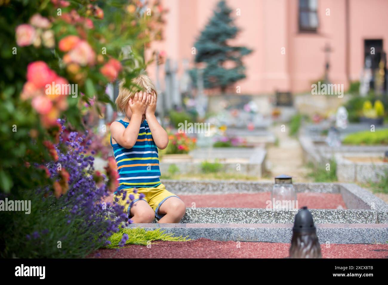 Little toddler boy, sitting on a cemetery, feeling sad on a grave Stock ...
