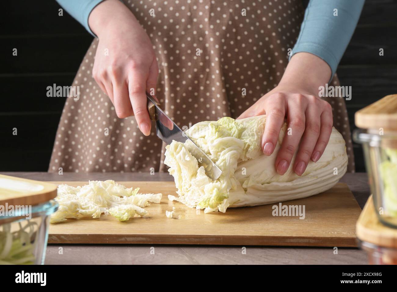 Healthy food. Woman cutting Chinese cabbage at grey table, closeup ...
