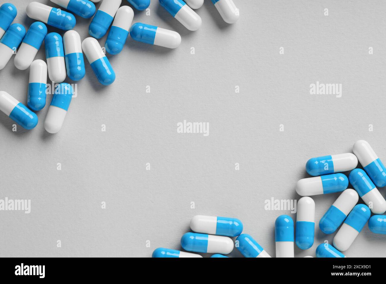Many antibiotic pills on grey background, top view and space for text ...