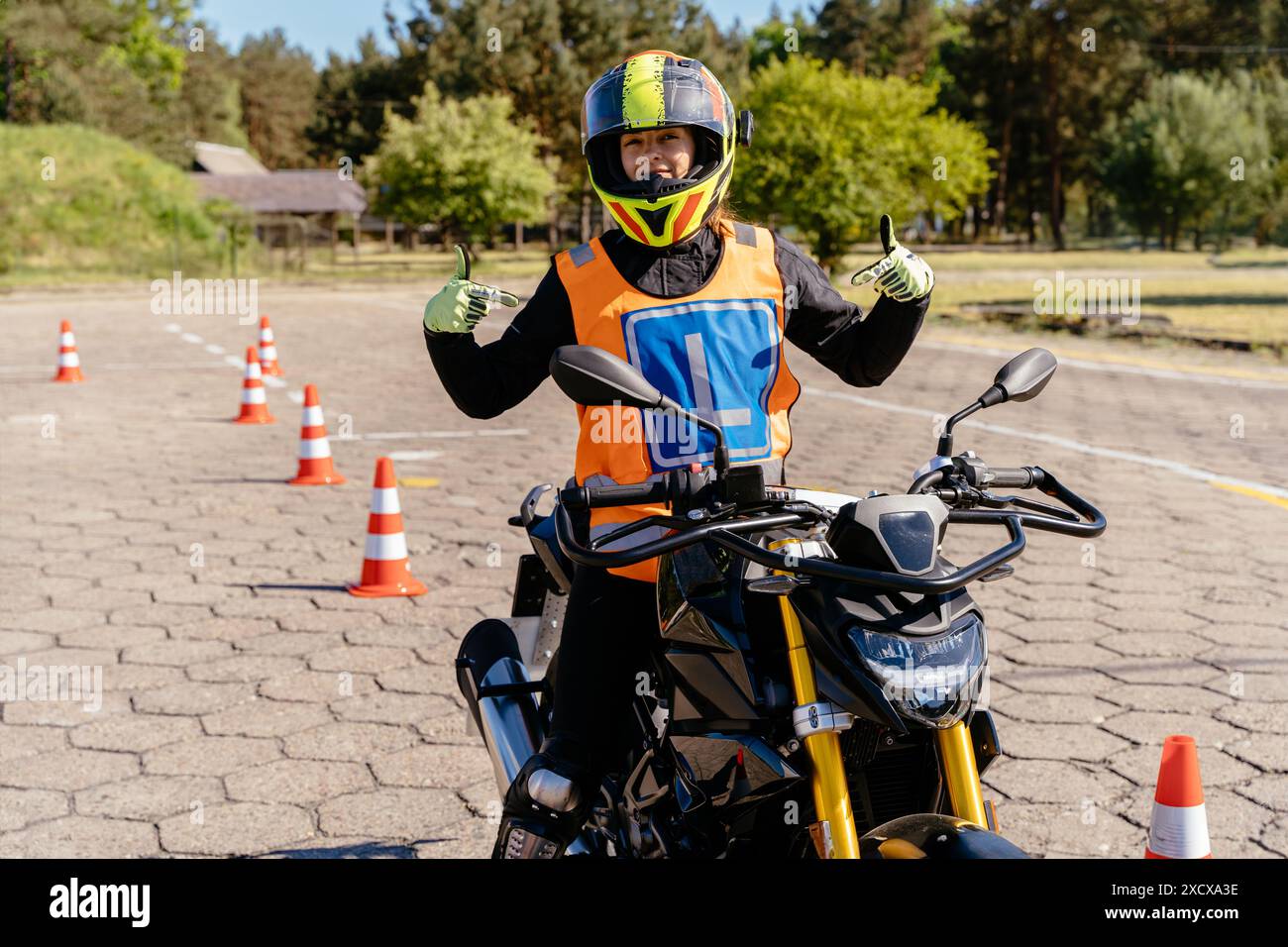 Female student with helmet taking motorcycle lessons and practicing ...