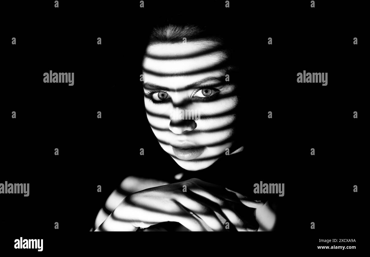 Womans Face Covered In Striped Shadows In Black And White Stock Photo ...