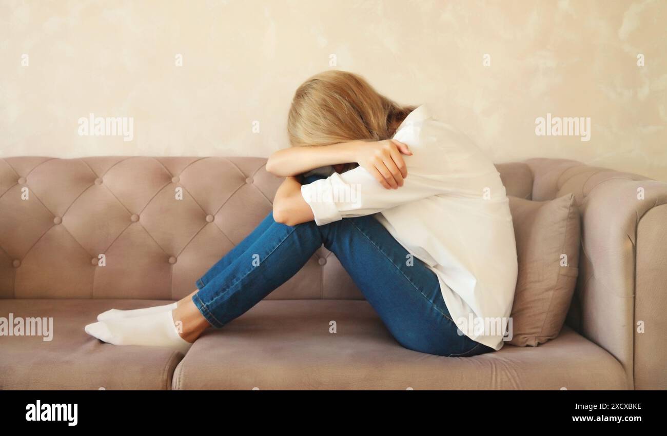 Upset sad crying woman covering her eyes and face with her hands while ...