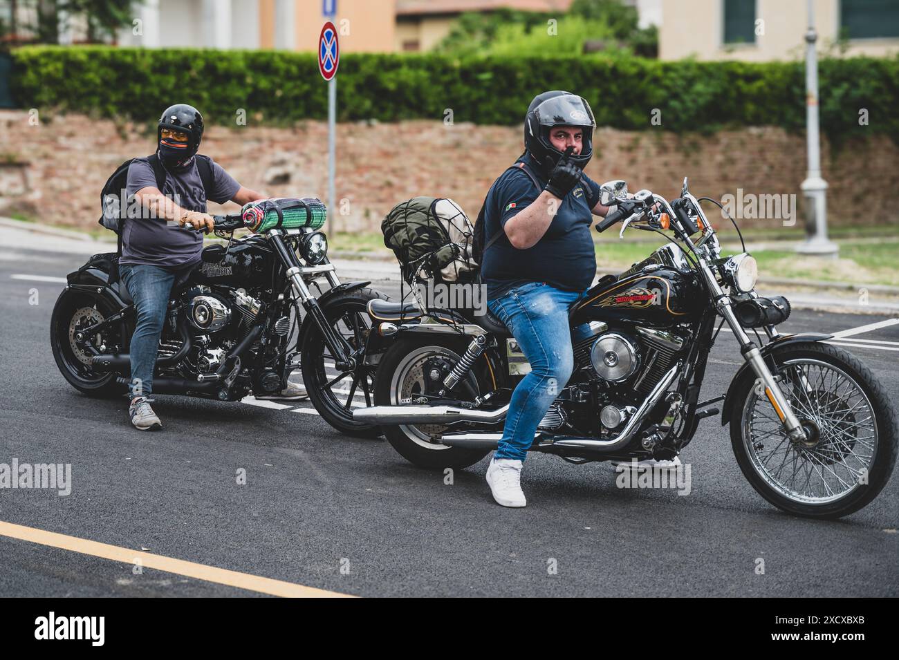 Two bikers on the road with their motorcycles, wearing protective ...