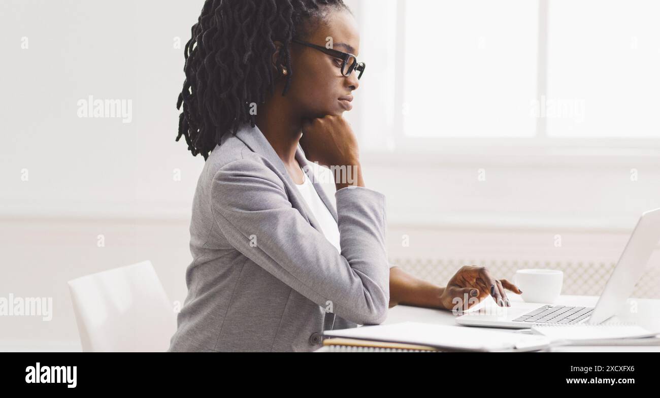 Lady at desk working diligently on laptop Stock Photo - Alamy
