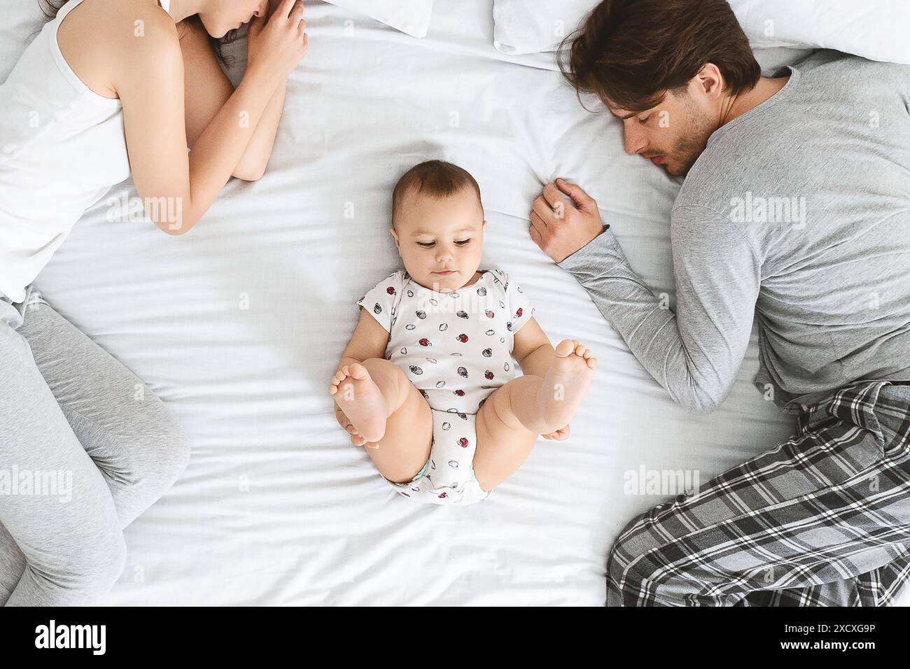 A Family of Three Sleeping Together in a White Bed Stock Photo - Alamy