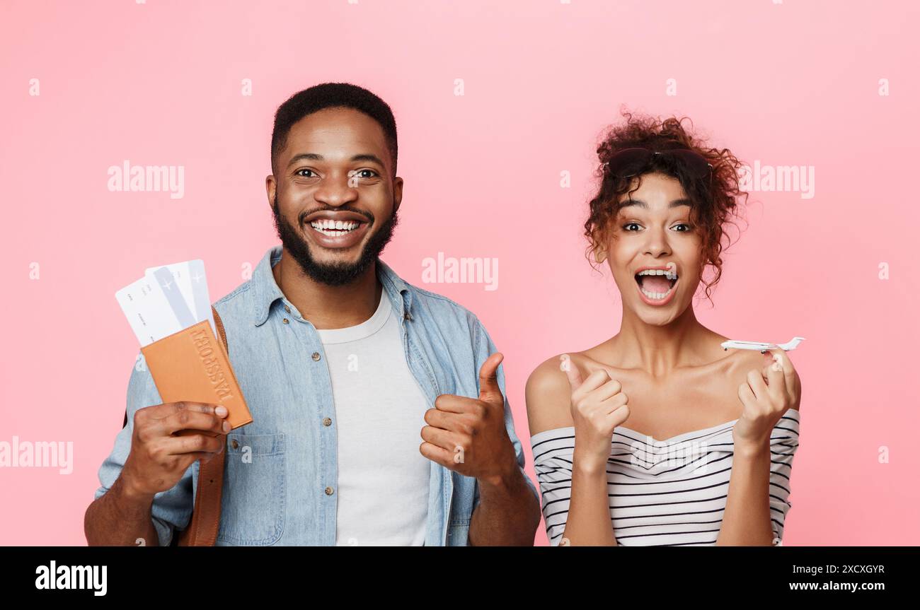 Excited couple holding flying tickets and showing thumbs up Stock Photo ...