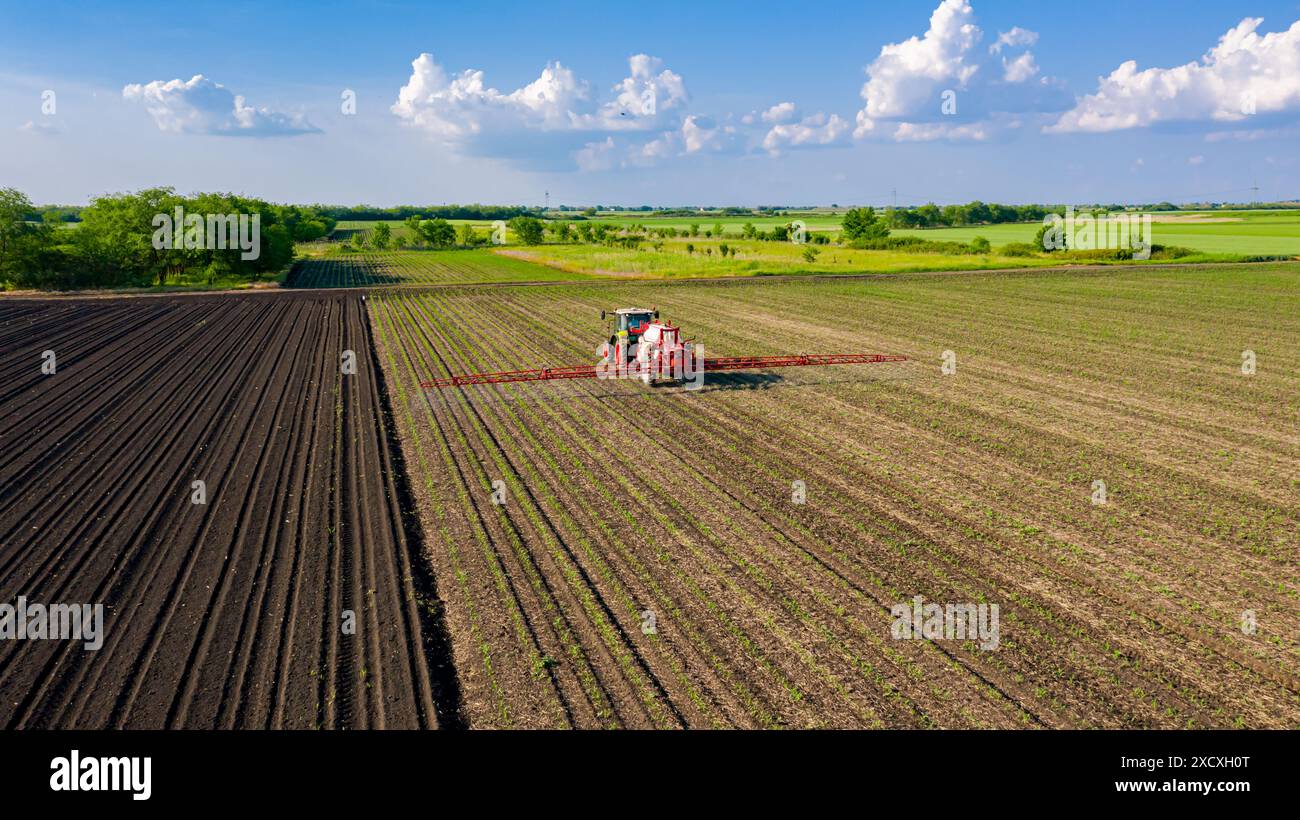 Above view on tractor until spraying farmland, dragging mounted wide ...