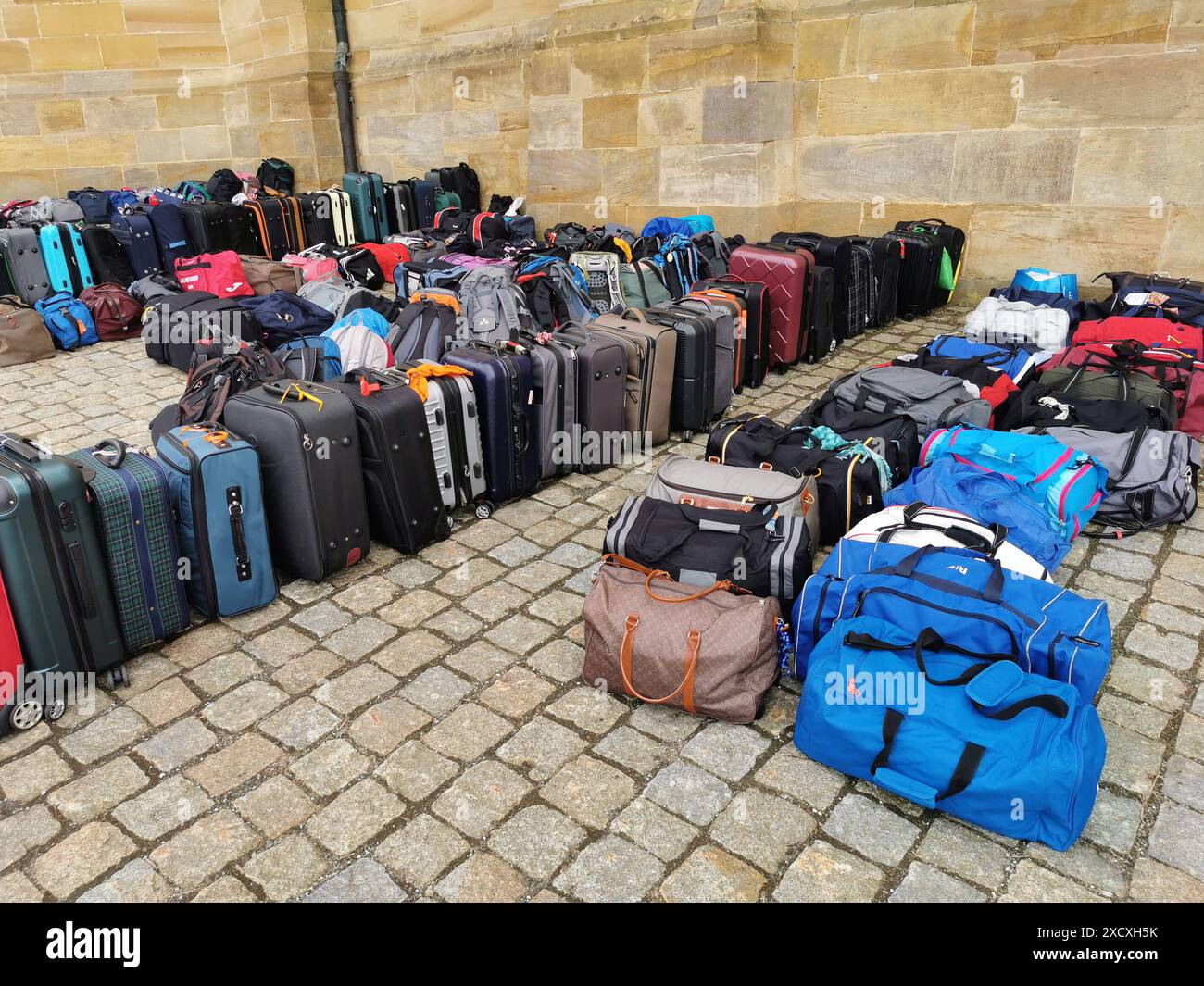 Das Reisegepäck einer Reisegruppe steht in Reihen auf dem Pflaster ...