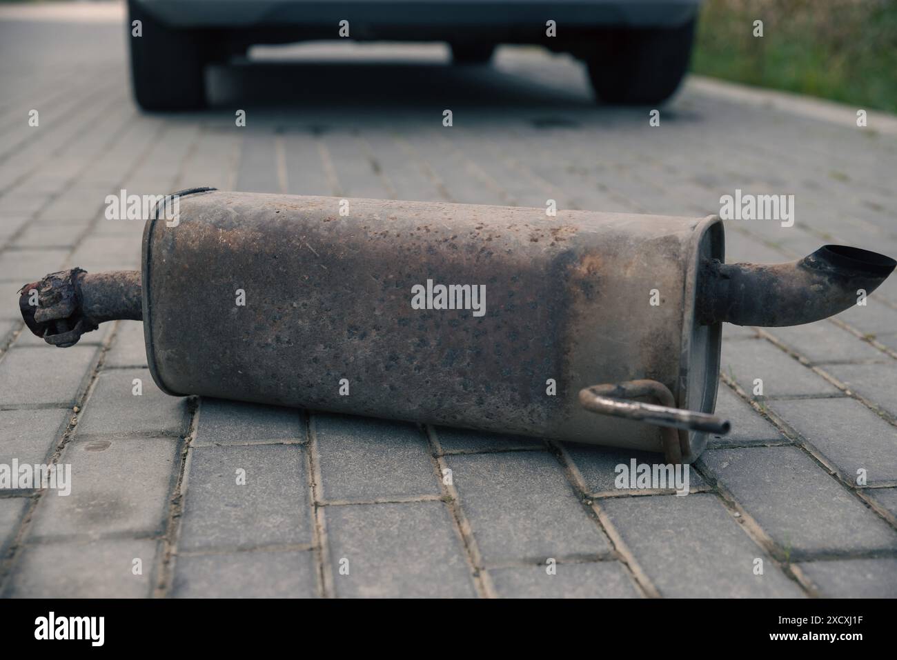 the rusty exhaust pipe, the car's muffler has fallen off and is lying ...