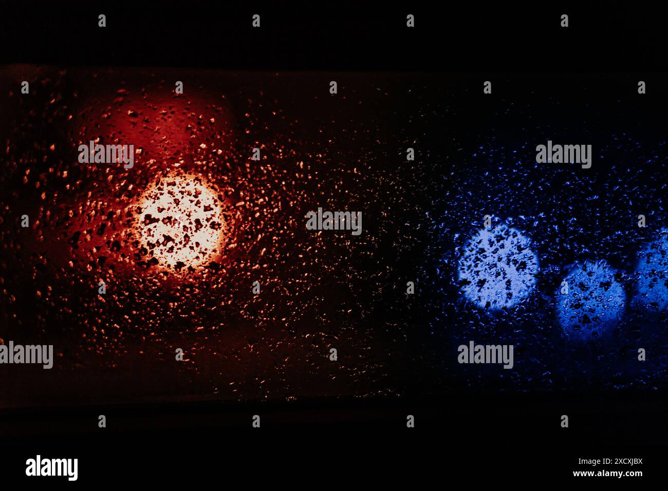 Raindrops and condensation on window at night with street lights ...
