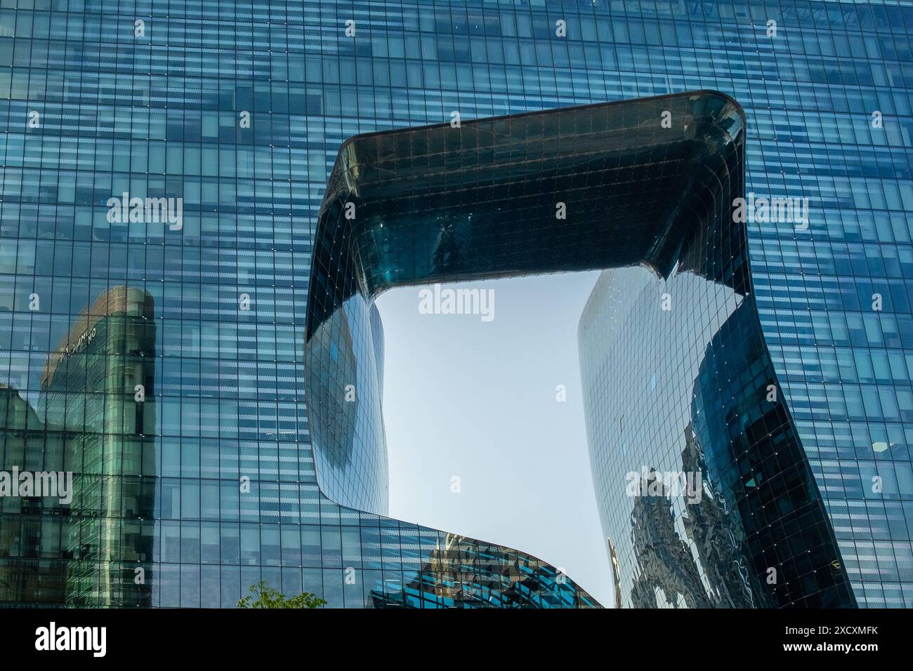 Modern curved glass building with open space and reflection in Dubai ...