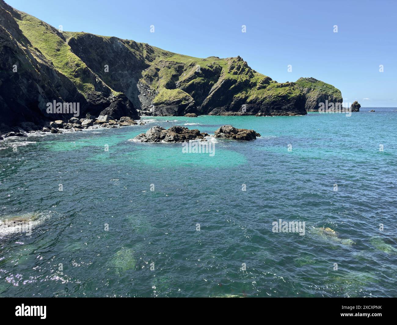The clear water at Mullion Cove, Cornwall, England on a bright sunny ...
