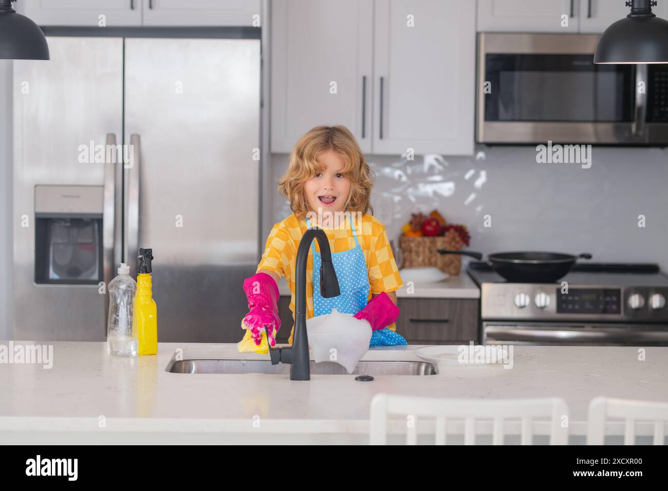 Housekeeping, home chores. Child help in washing dishes at kitchen. Kid ...