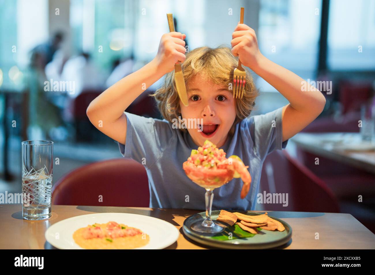 Funny surprised Little boy eating seafood in cafe. Kid eat Food fish ...