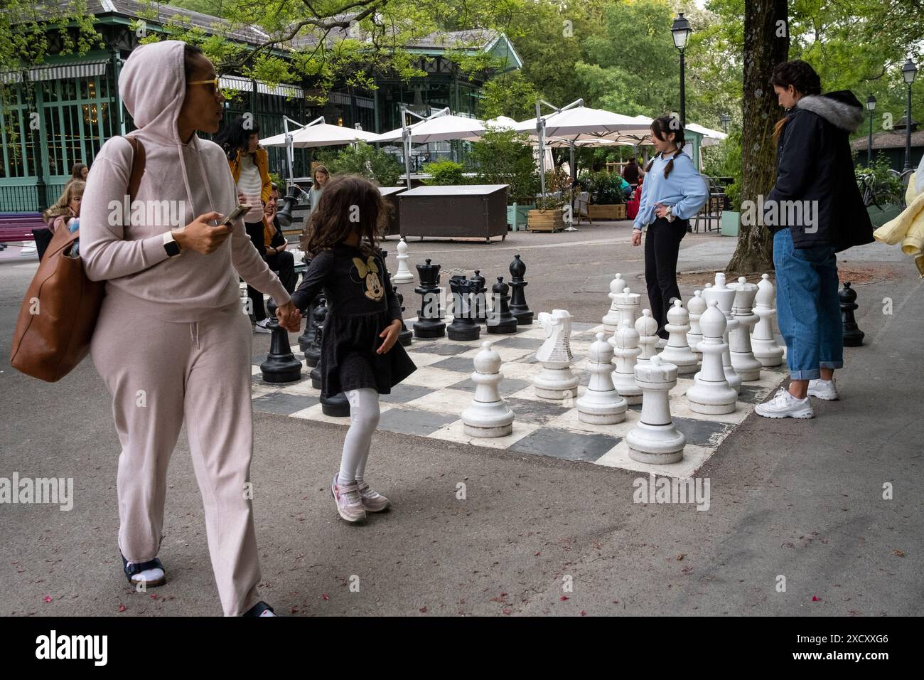Family and child playing a game of giant chess in the Park des Bastions ...