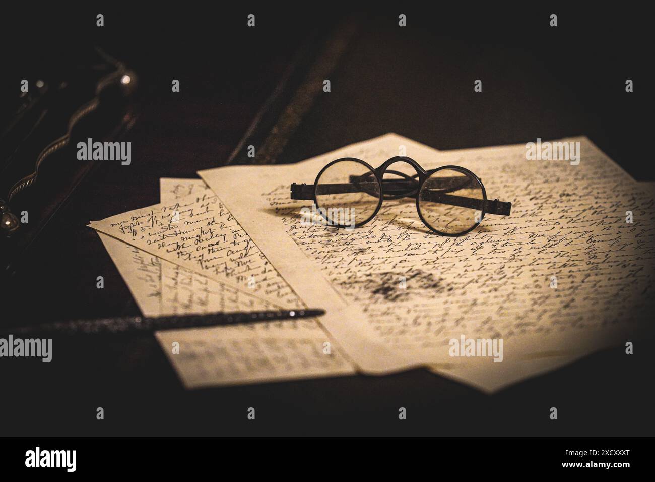 The old historic antique eyeglasses on a stack of papers with cursive ...