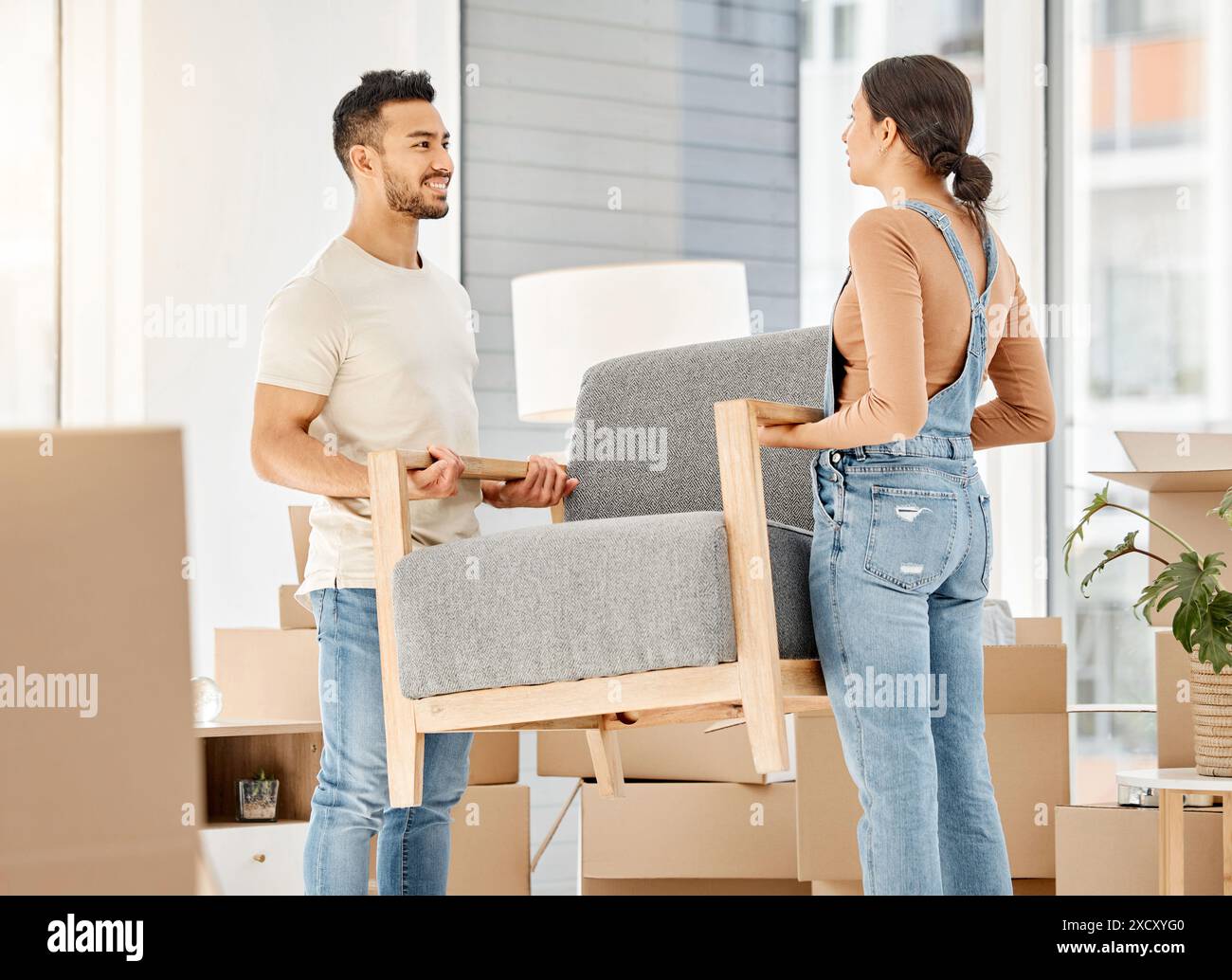 Smile, couple and moving furniture in new house for renovations, boxes ...