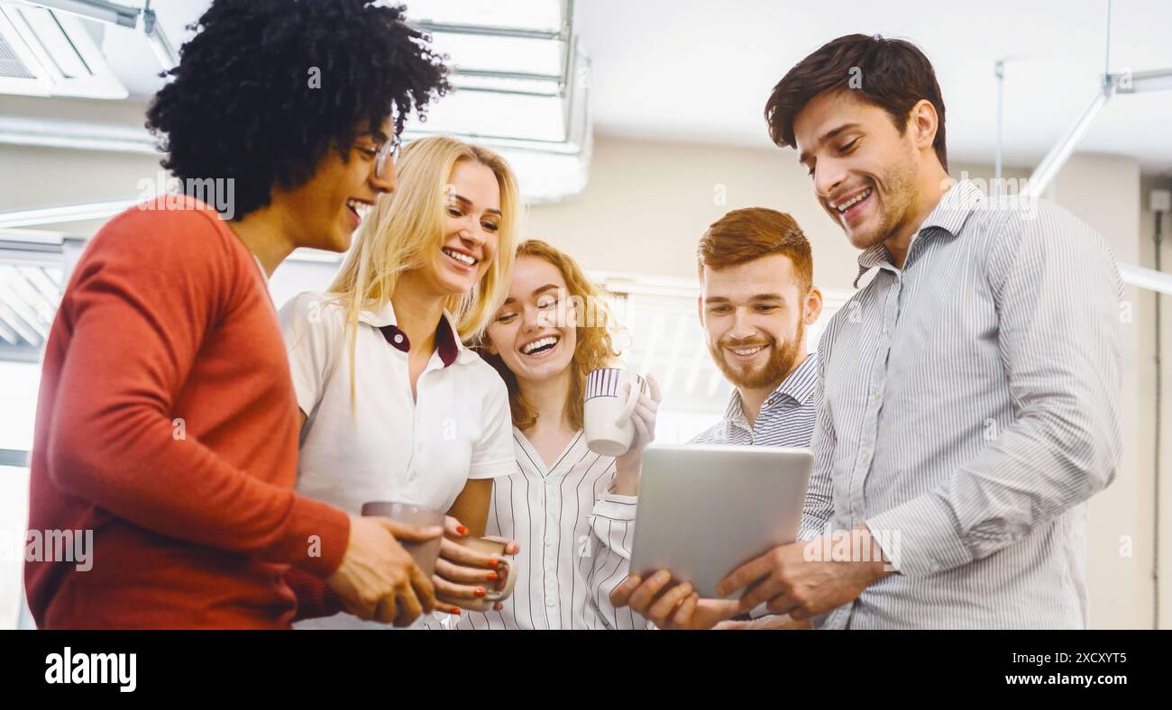 Group of Employees Standing Around a Tablet Stock Photo - Alamy