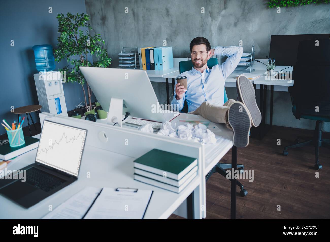 Full body portrait of elegant corporate worker man put legs desk hold ...