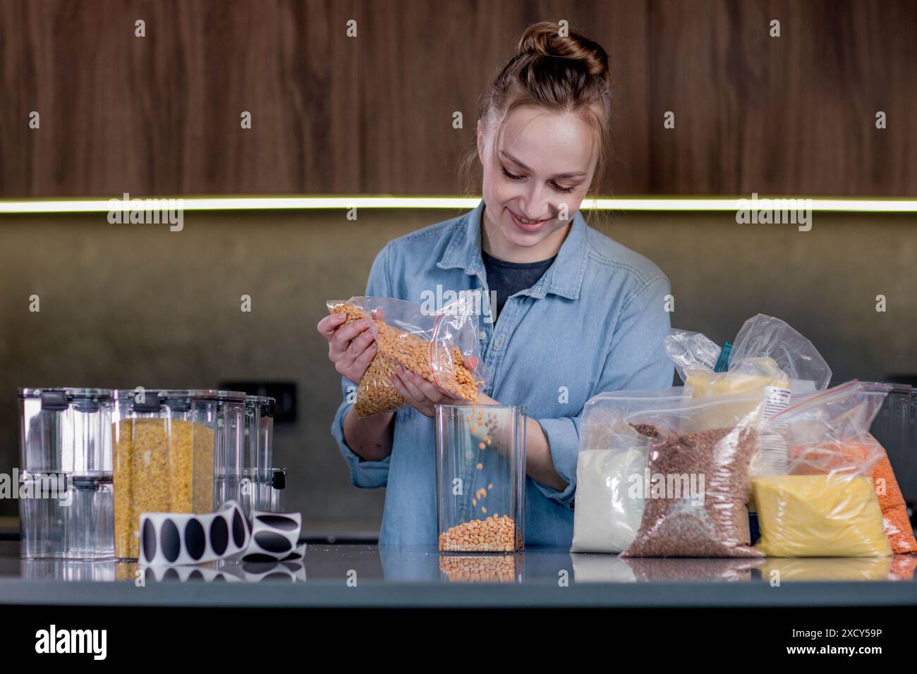 A woman uses containers to organize food in the kitchen. Layout and ...