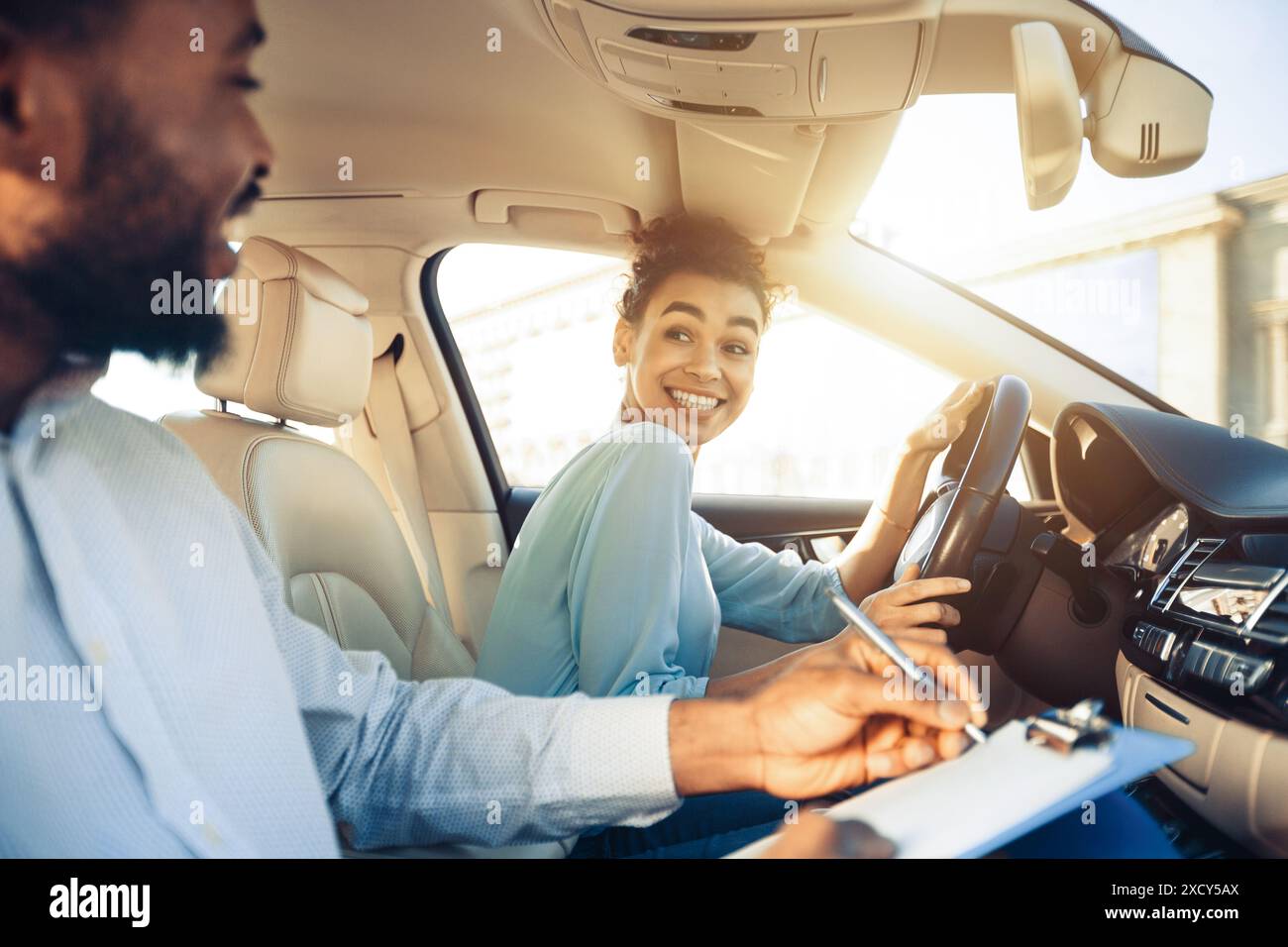 Driving Instructor Evaluating Student During Driving Lesson in Car ...
