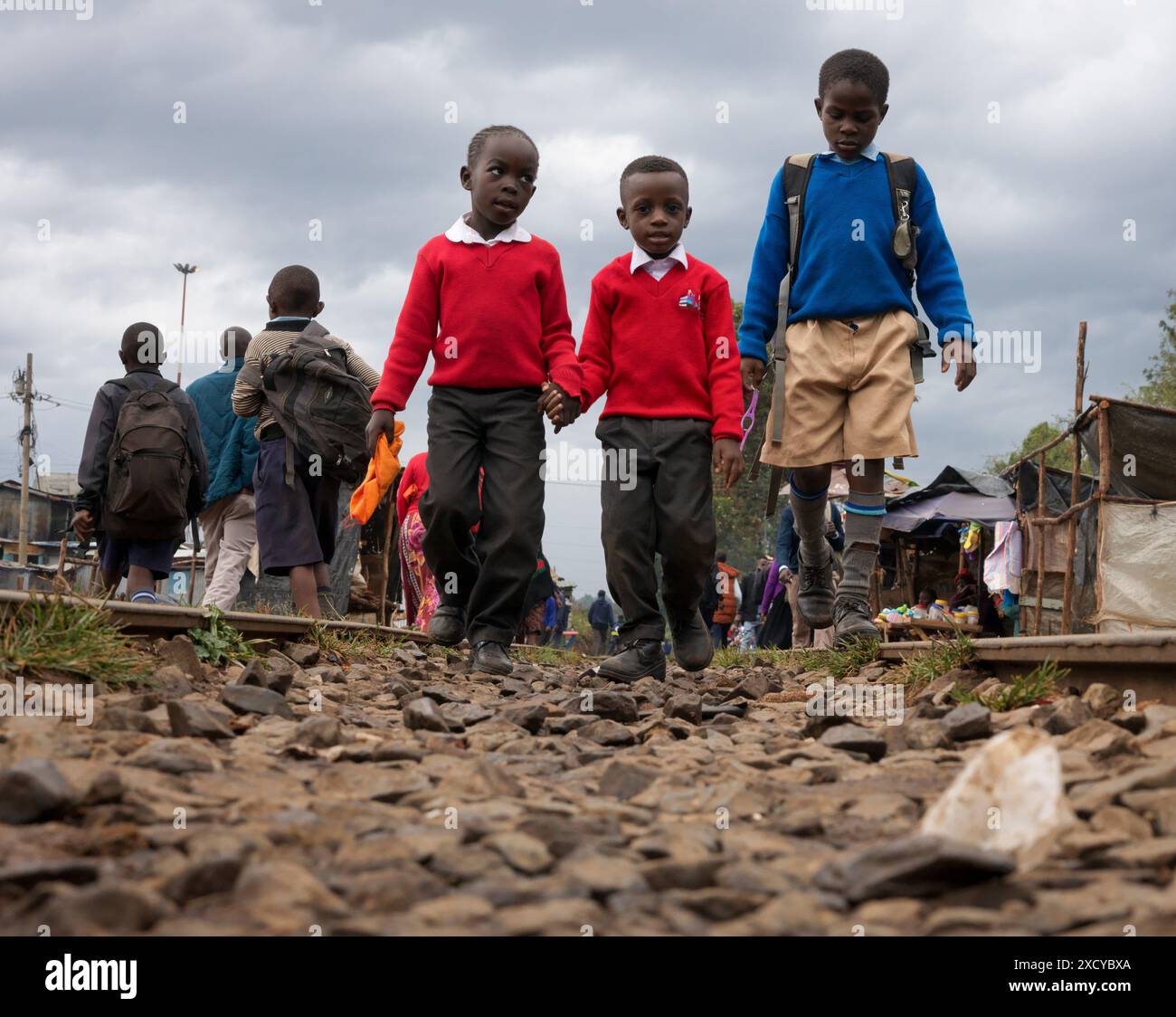 Schoolchildren walking along a railway line to or from school in Kibera ...