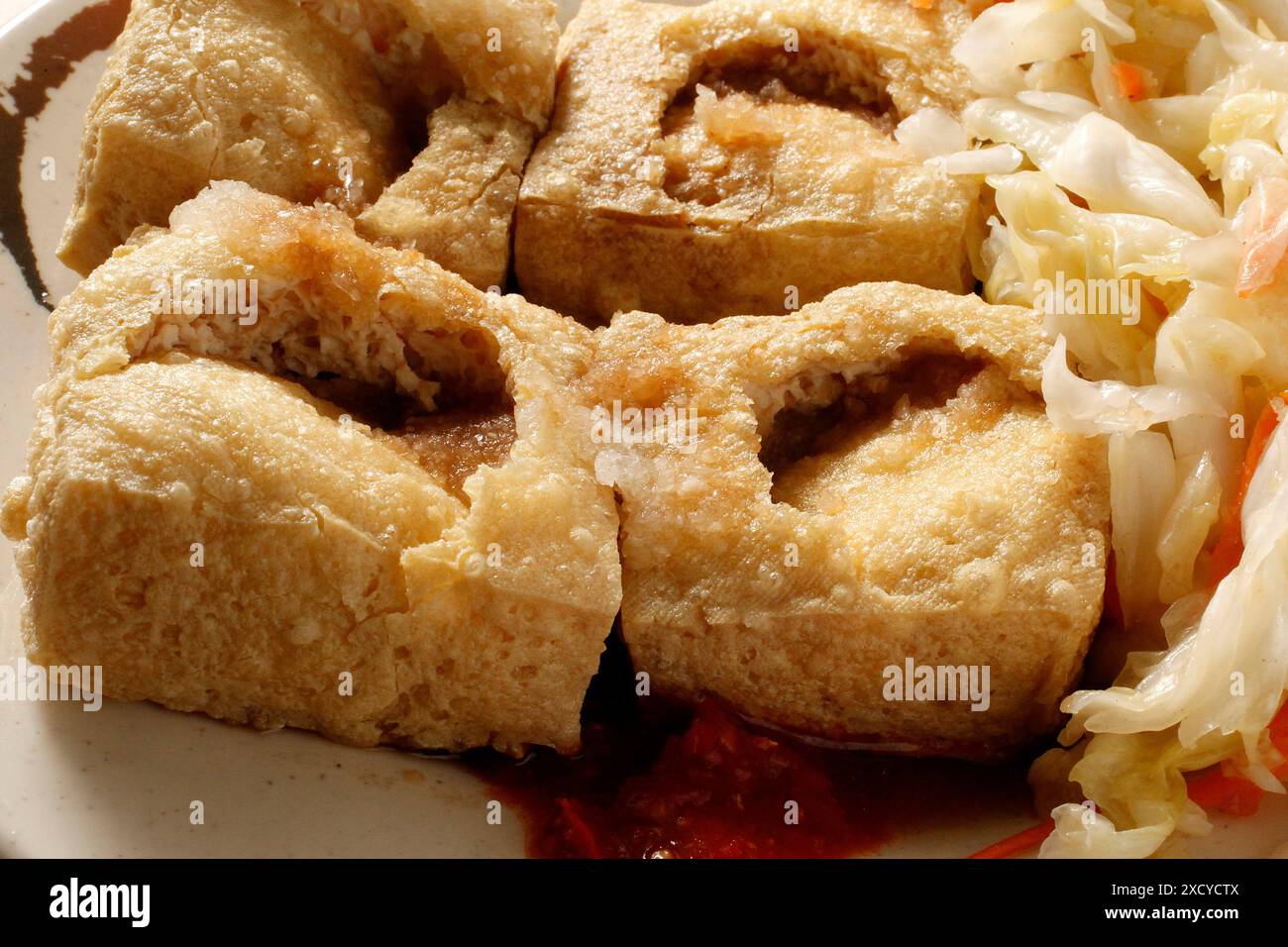 A close-up of deep-fried stinky tofu with a side of pickled vegetables ...