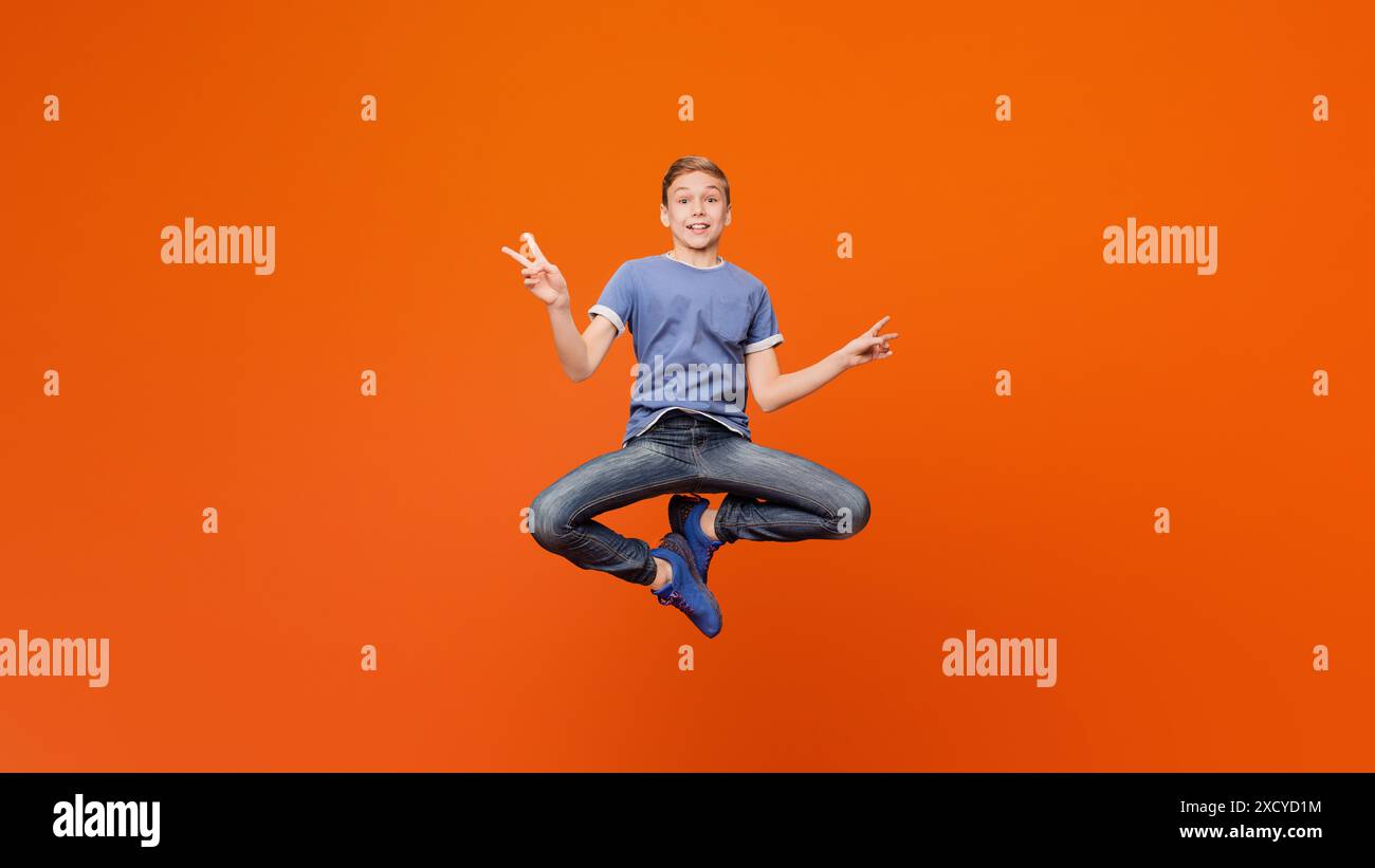 Cute boy jumping and gesturing peace signs Stock Photo - Alamy