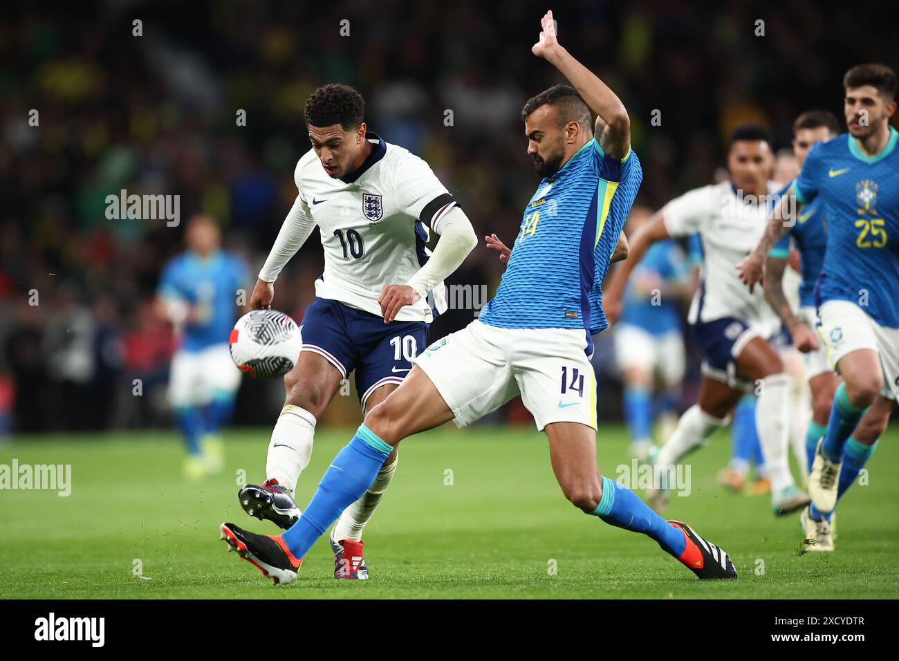 Jude Bellingham of England is tackled by Fabricio Bruno of Brazil ...