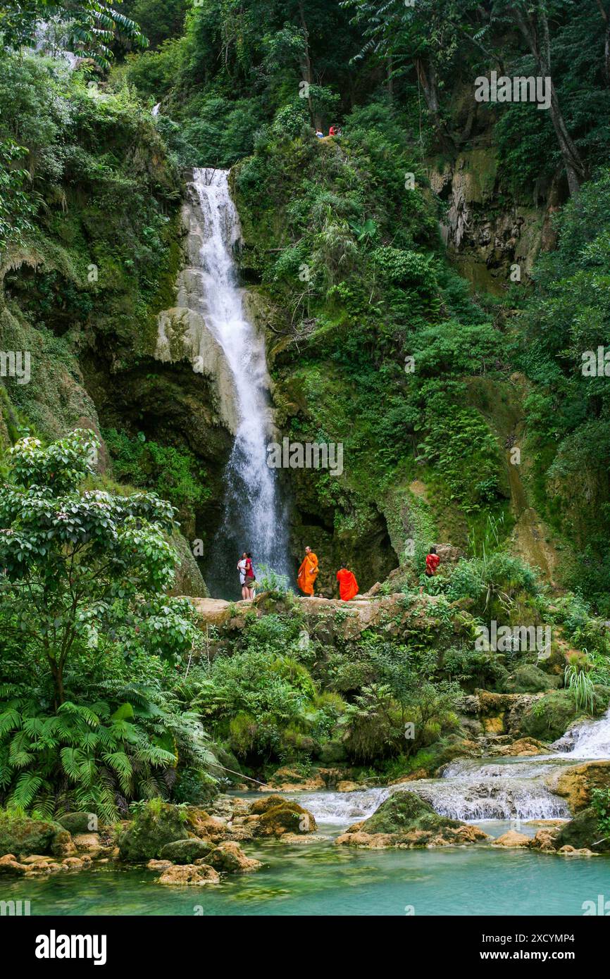 Laos, Luang Prabang. Tourists and buddhist monks visiting a waterfall ...