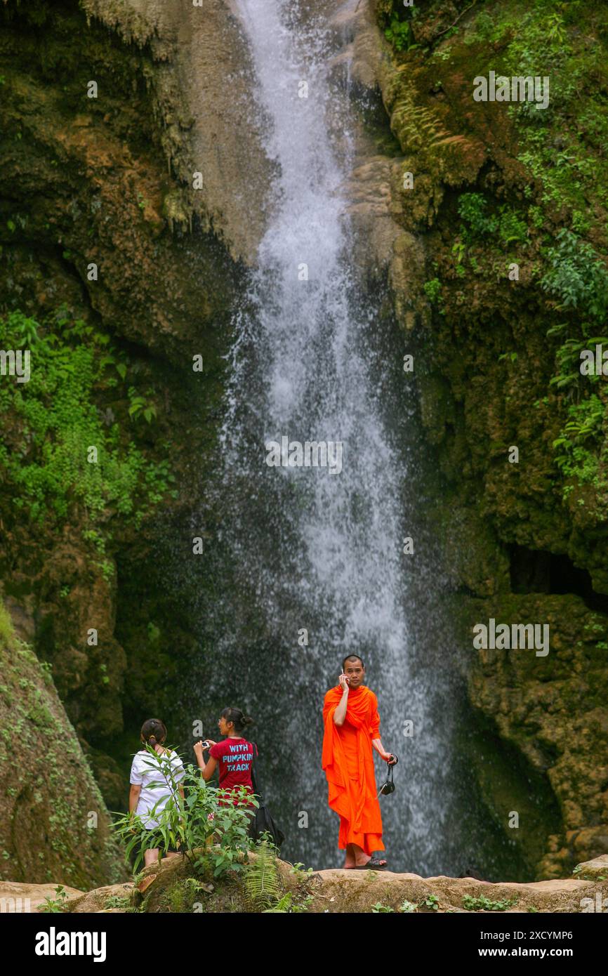 Laos, Luang Prabang. Tourists and buddhist monks visiting a waterfall ...