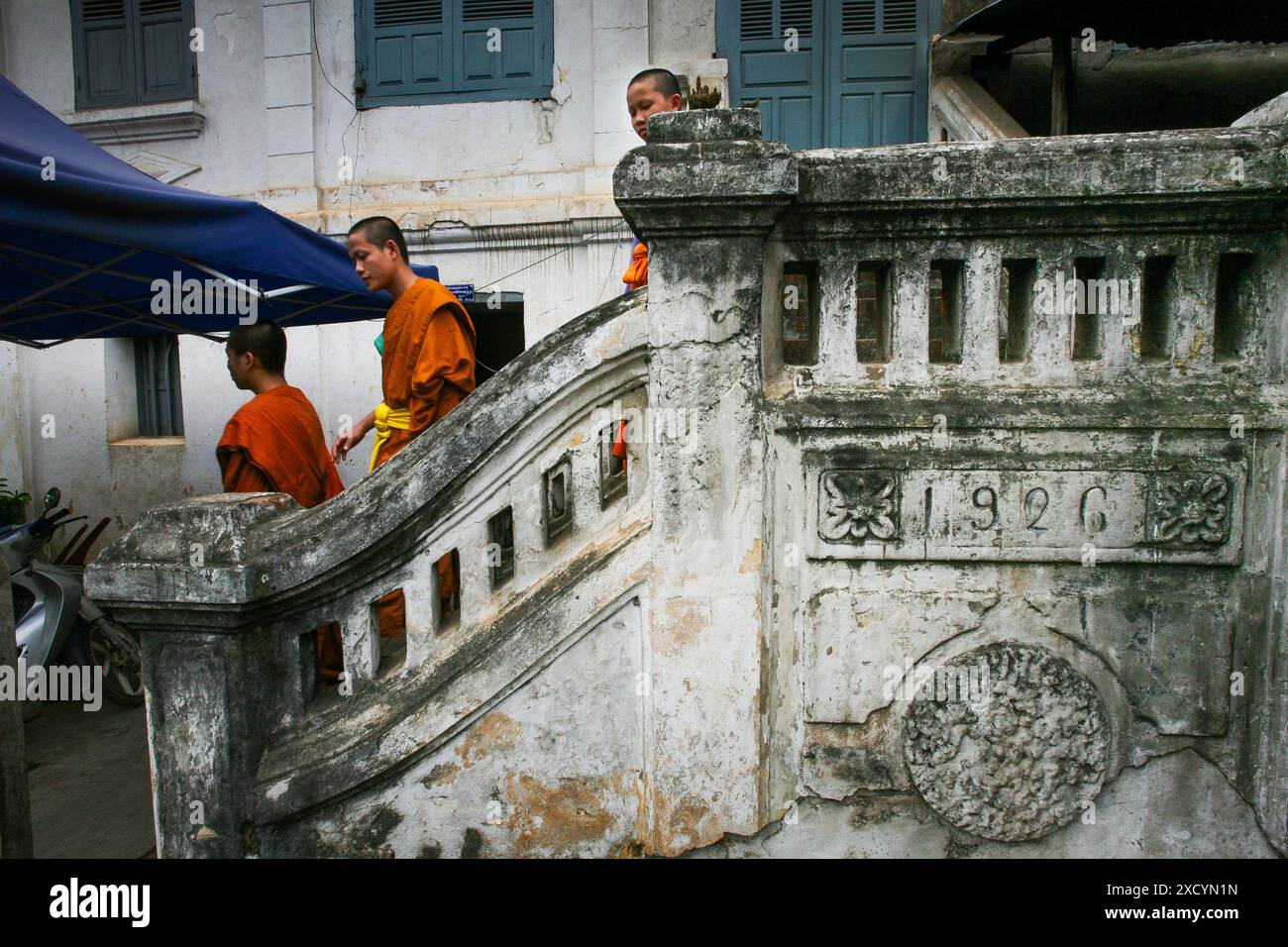 Laos, Luang Prabang - Buddhist monks stand on the stairs of a French ...