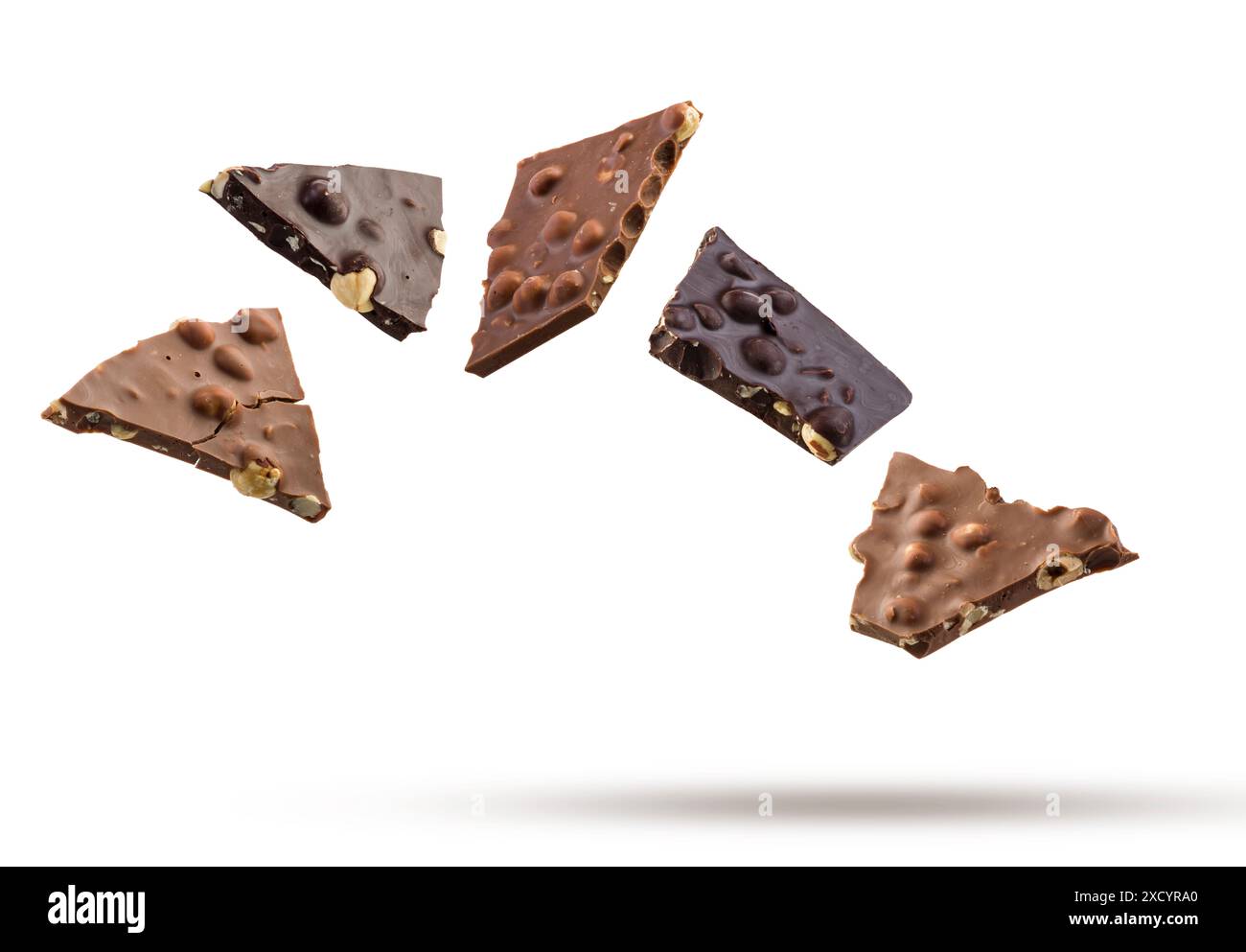 Milk and dark pieces of hazelnut chocolate flying on white background ...