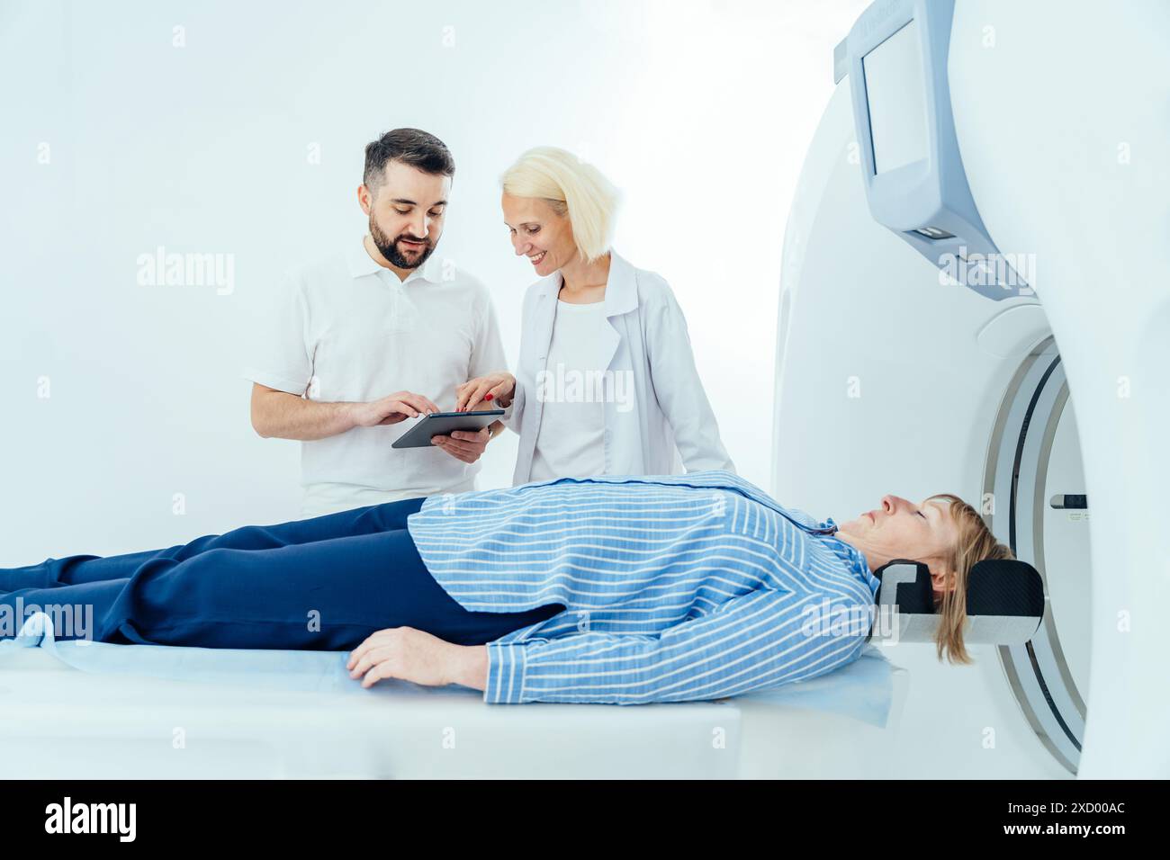 radiologist holding x-ray diagnosis while patient lying on ct scanner ...