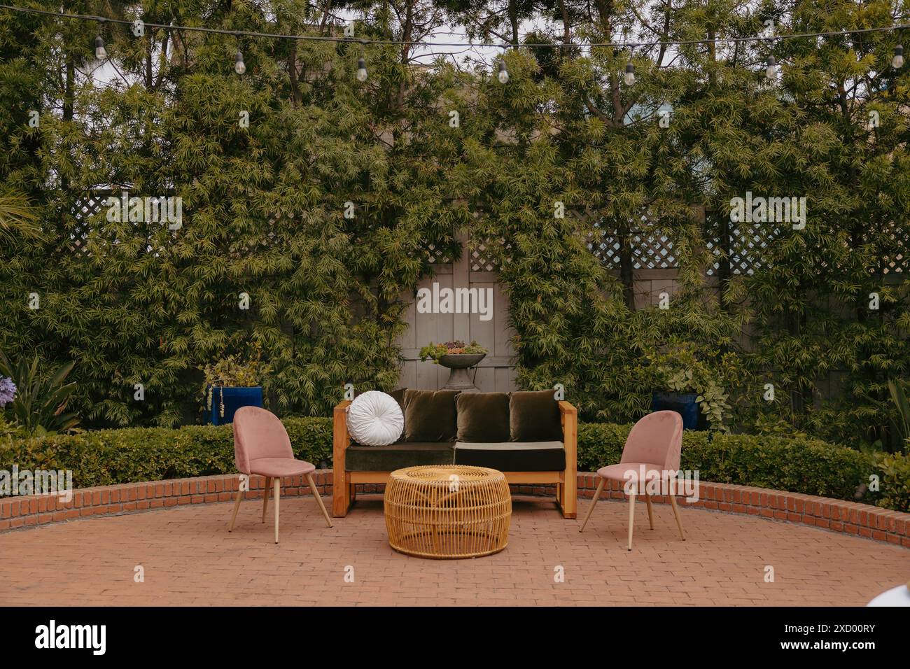 An outdoor patio setup with pink chairs, a green sofa, and a wicker ...