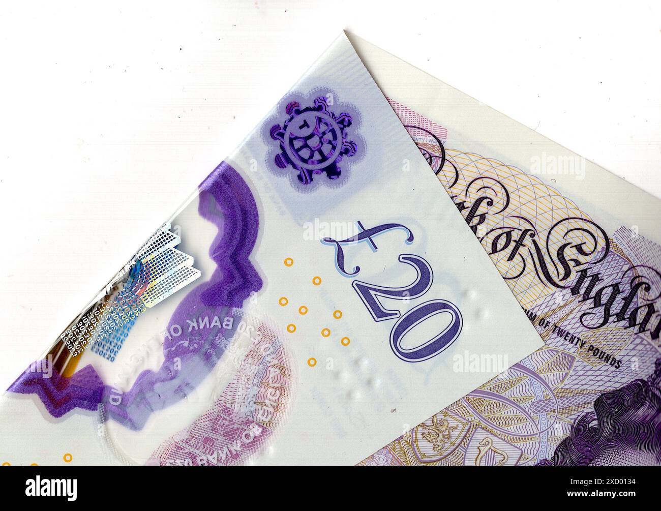 A folded modern £20 polymer banknote from the United Kingdom on a white ...