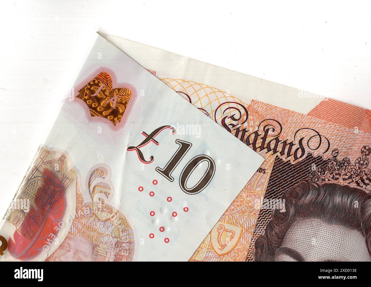 A folded modern £10 polymer banknote from the United Kingdom on a white ...