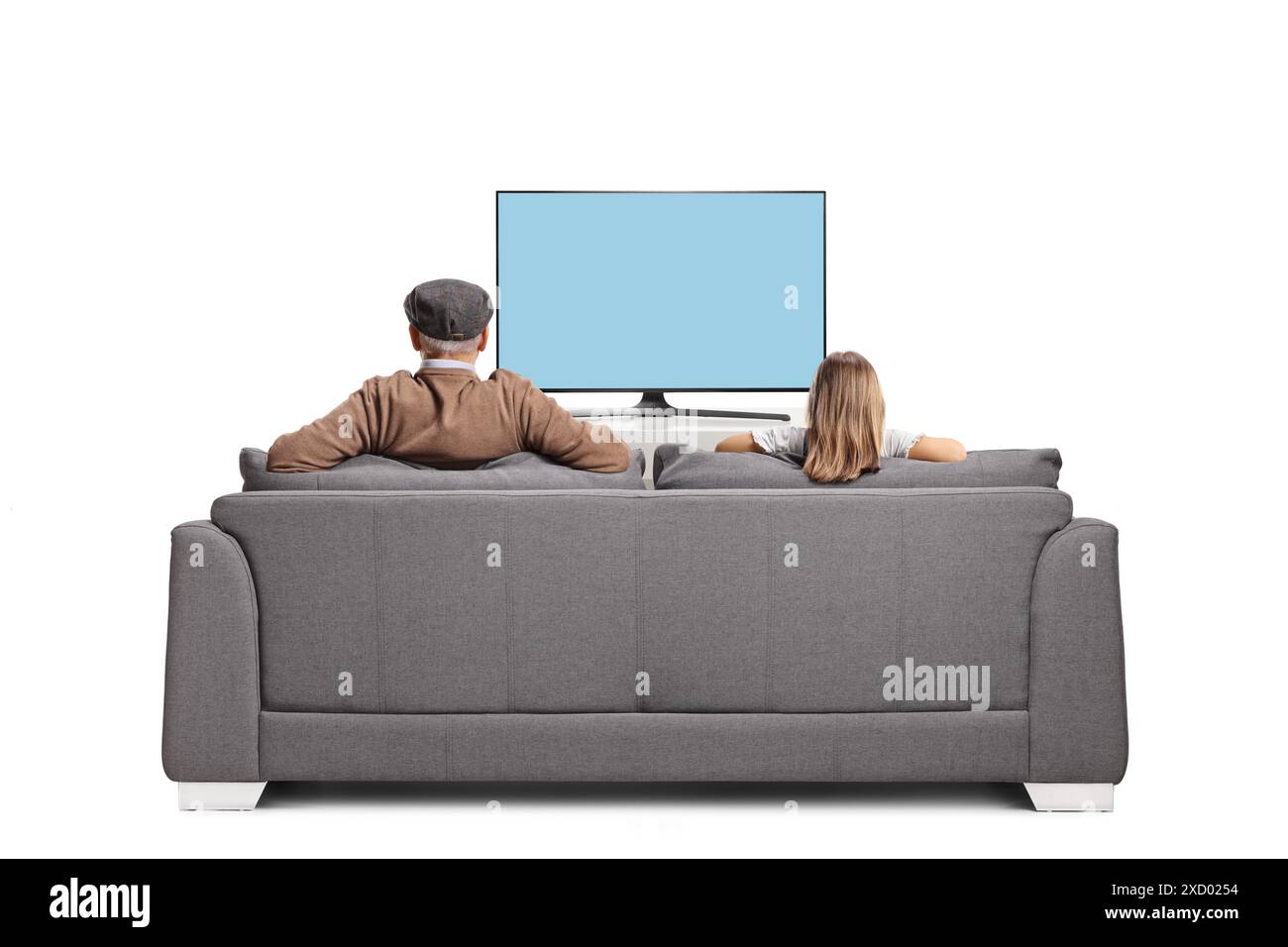 Rear view shot of a grandfather and girl watching tv seated on a sofa ...