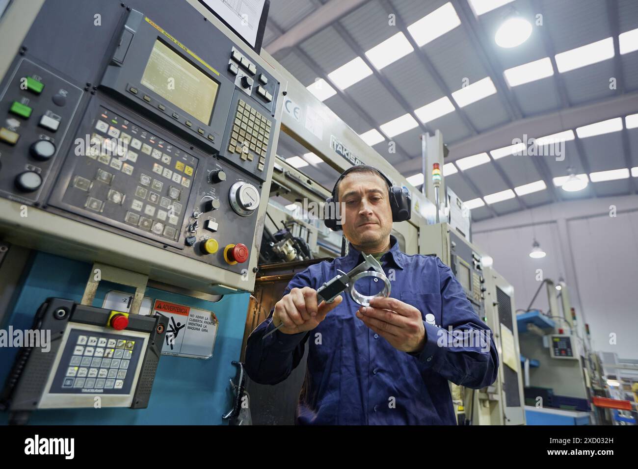 Worker measuring with caliper. Area automated CNC lathes. Machined ...