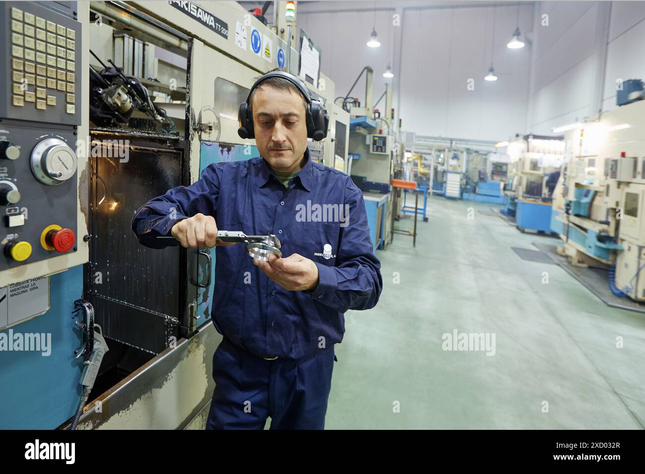 Worker measuring with caliper. Area automated CNC lathes. Machined ...