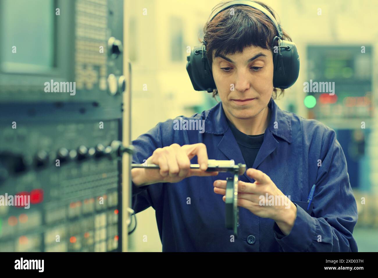 Worker measuring with caliper. Area automated CNC lathes. Machined ...