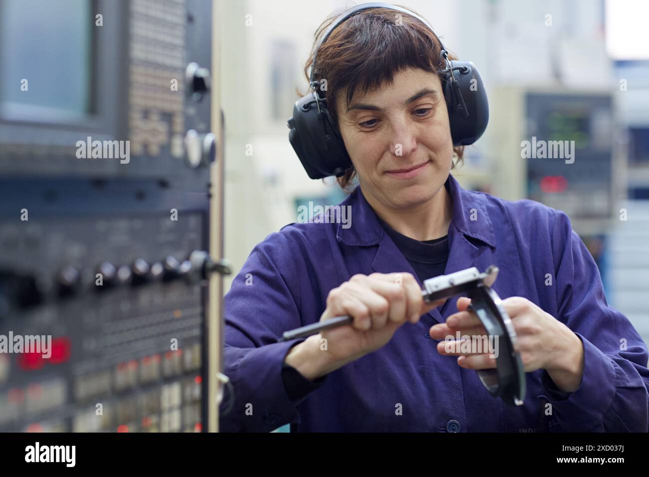 Worker measuring with caliper. Area automated CNC lathes. Machined ...