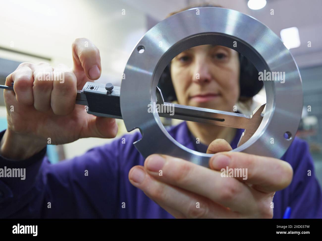 Worker measuring with caliper. Area automated CNC lathes. Machined ...