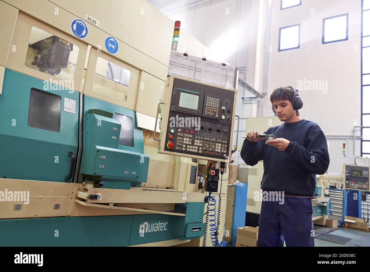 Worker measuring with caliper. Area automated CNC lathes. Machined ...