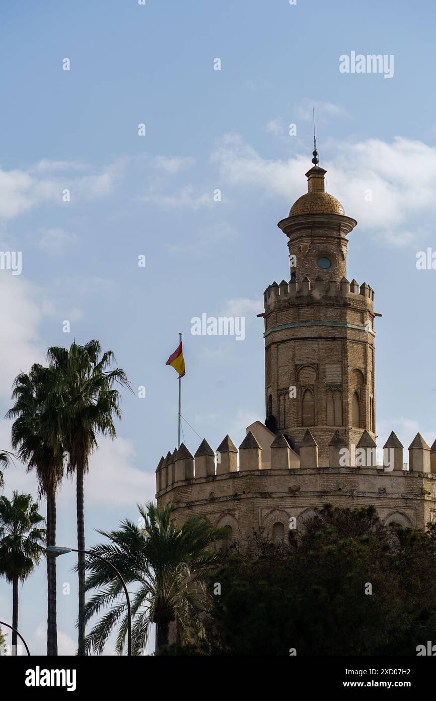 The torre del oro tower in seville, spain with a spanish flag flying ...