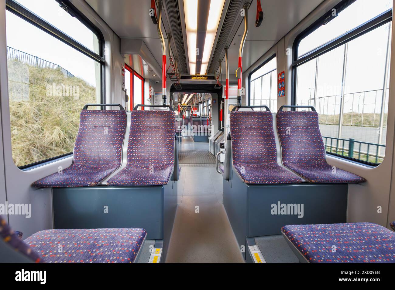Interior of the empty Dutch tram, empty seats, white walls, big windows ...